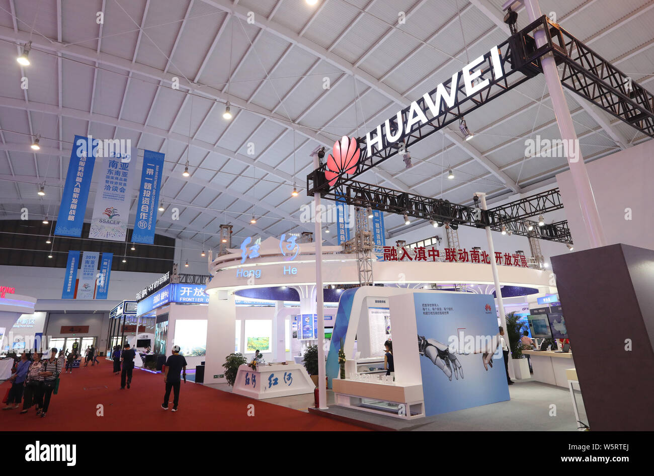 People visit the stand of Huawei during an expo in Kunming city ...