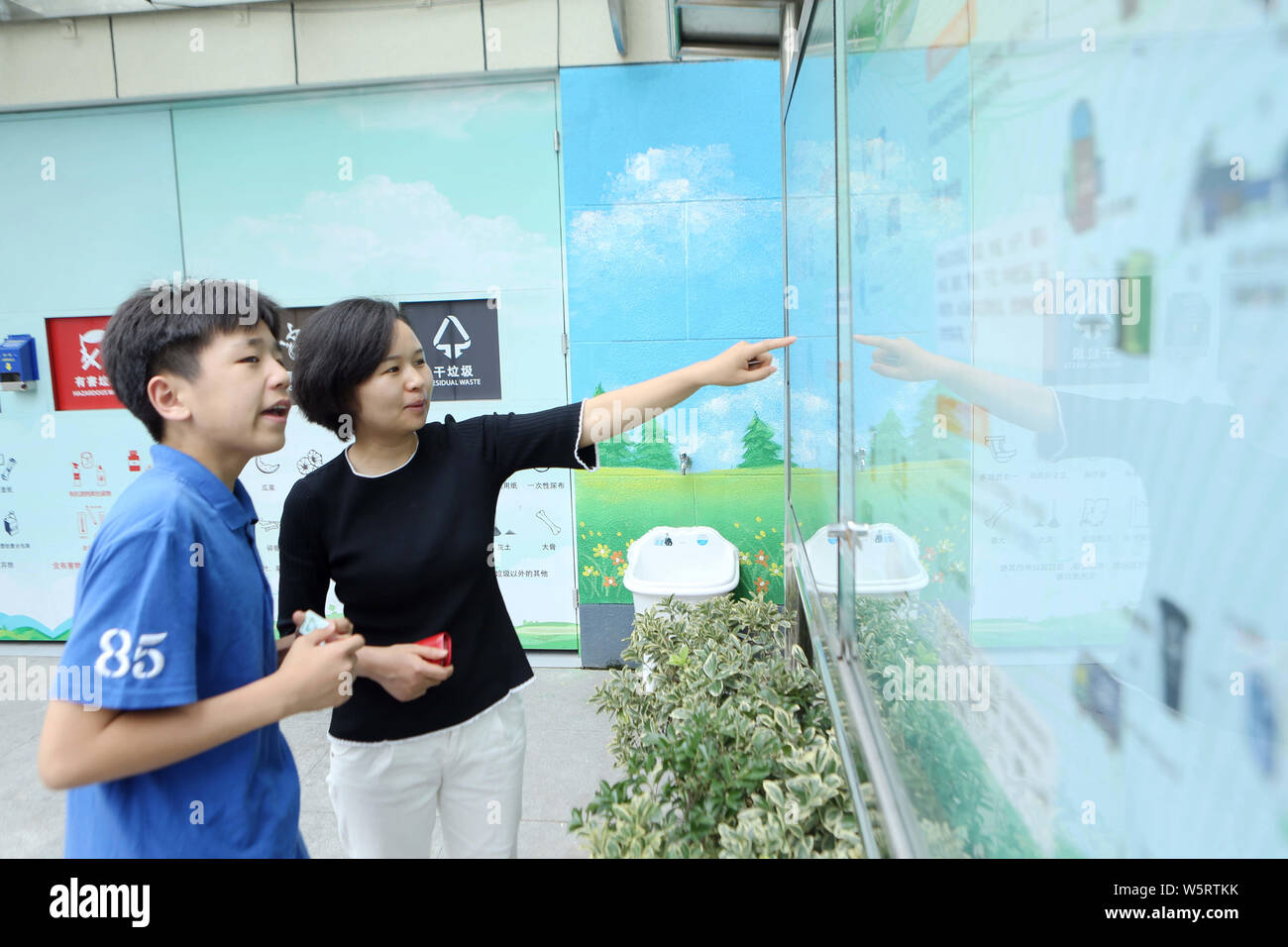 Local residents use QR code cards to open different bins to put their ...