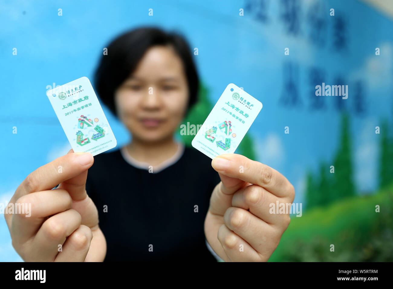 Local residents shows QR code cards used to open different bins to put ...
