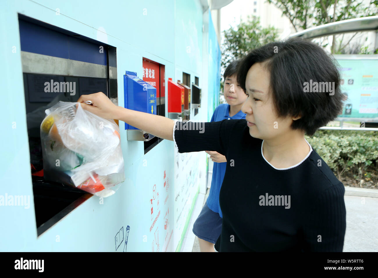 Local residents use QR code cards to open different bins to put their ...