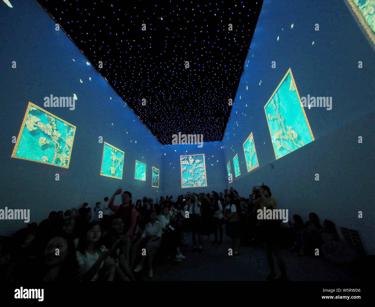 Visitors view or take pictures of a projection of art by Dutch post ...