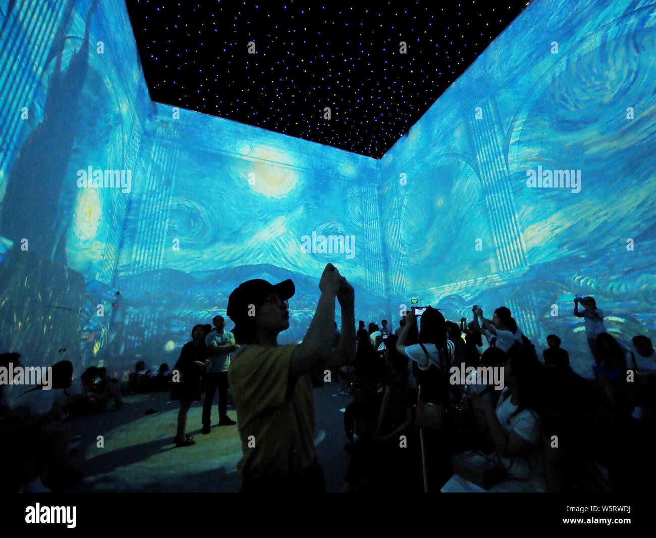 Visitors view or take pictures of a projection of art by Dutch post ...