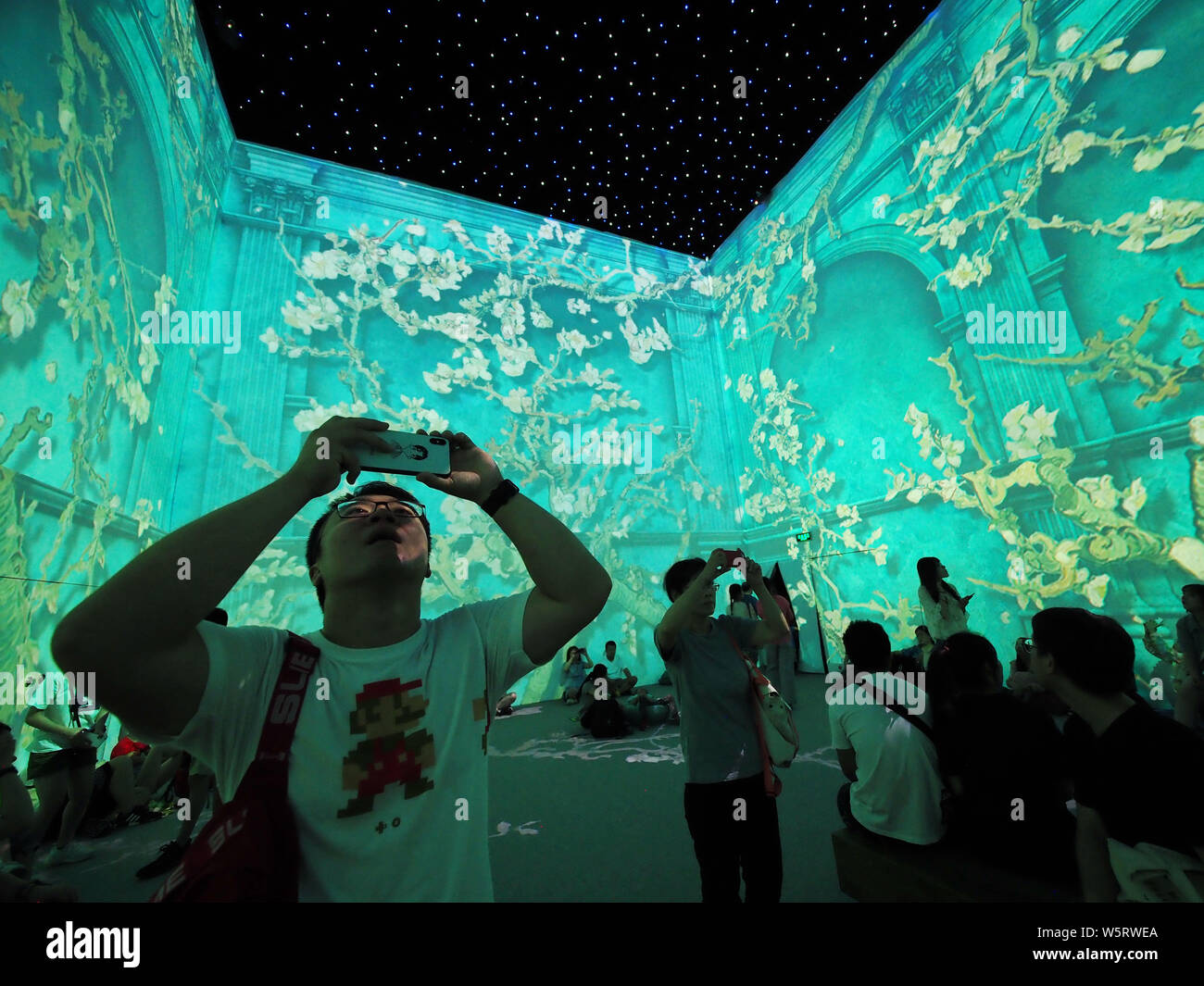 Visitors view or take pictures of a projection of art by Dutch post ...