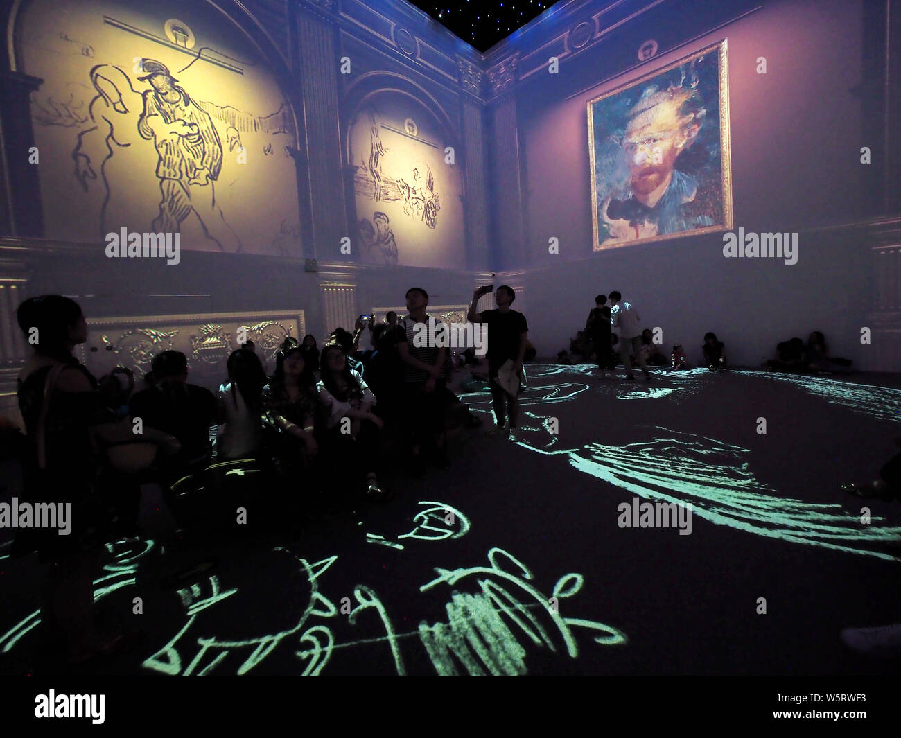 Visitors view or take pictures of a projection of art by Dutch post ...