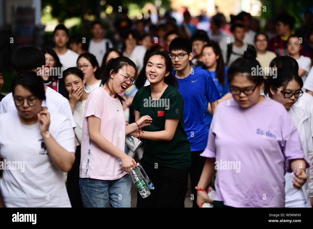 A crowd of young Chinese student examinees walk out from a middle ...