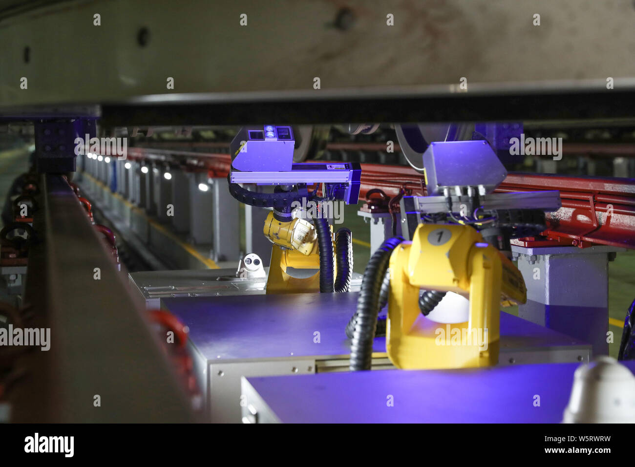 A Chinese worker operates smart robot arms to inspect and repair the ...