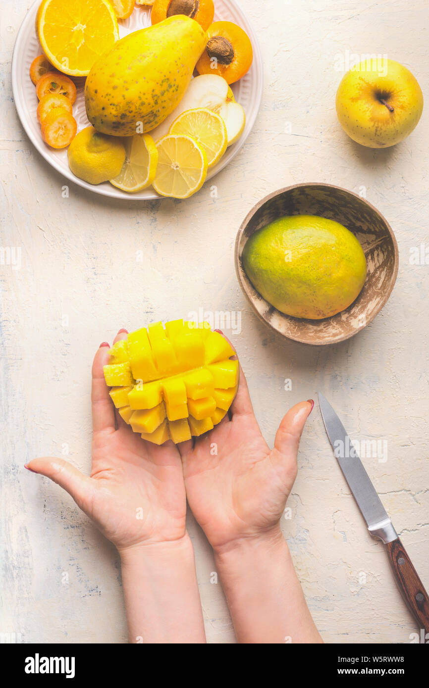 Mango preparation step by step. Female hands holding half diced mango ...
