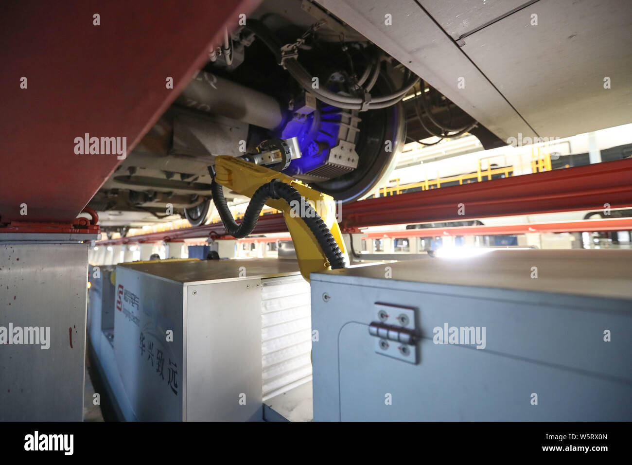 A Chinese worker operates smart robot arms to inspect and repair the ...