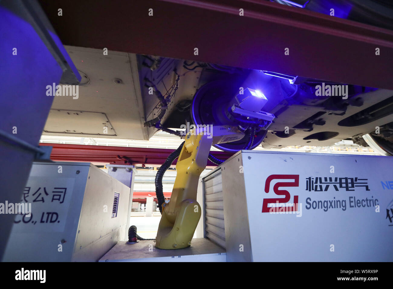 A Chinese worker operates smart robot arms to inspect and repair the ...