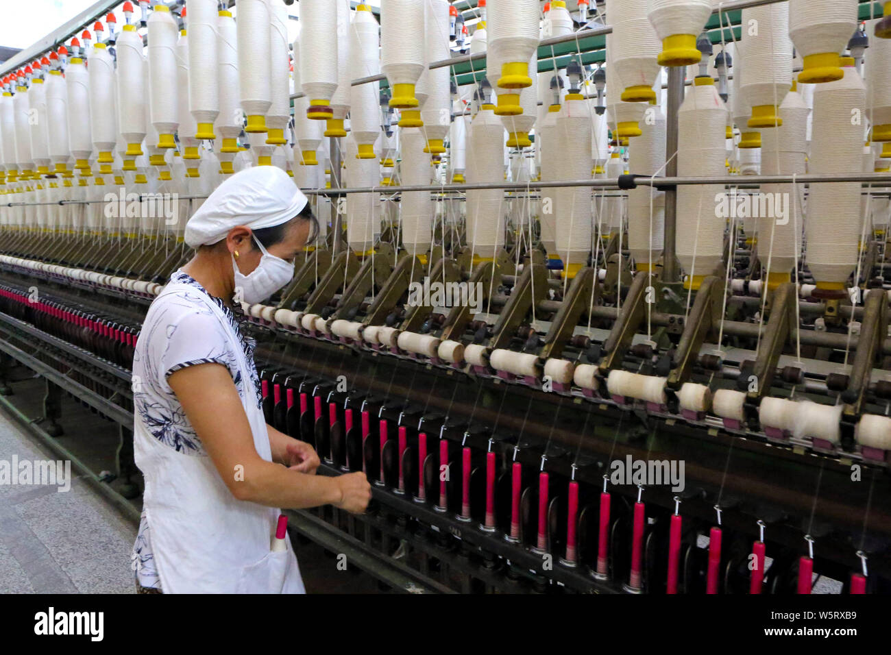 --FILE--A female Chinese worker handles production of yarn at a textile factory in Nanping city ...