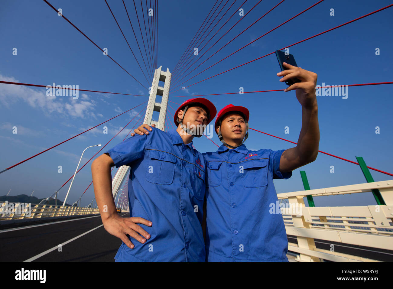 Chinese workers pose for photos on the Second Poyang Lake Bridge ...