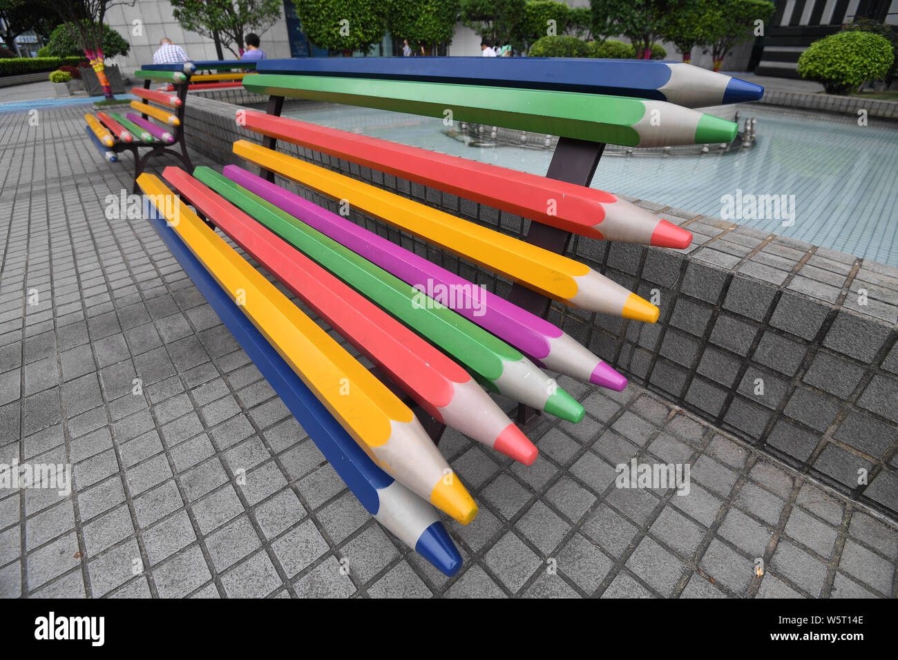 Colored pencil benches are pictured at a square amongst office ...
