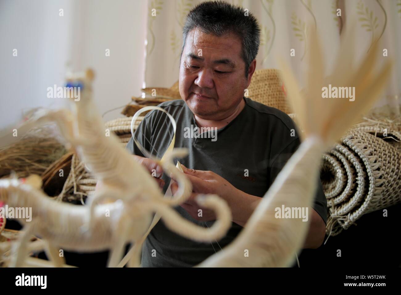 Chinese craftsman Tang Yunlun makes a dragon boat through using pteris ...