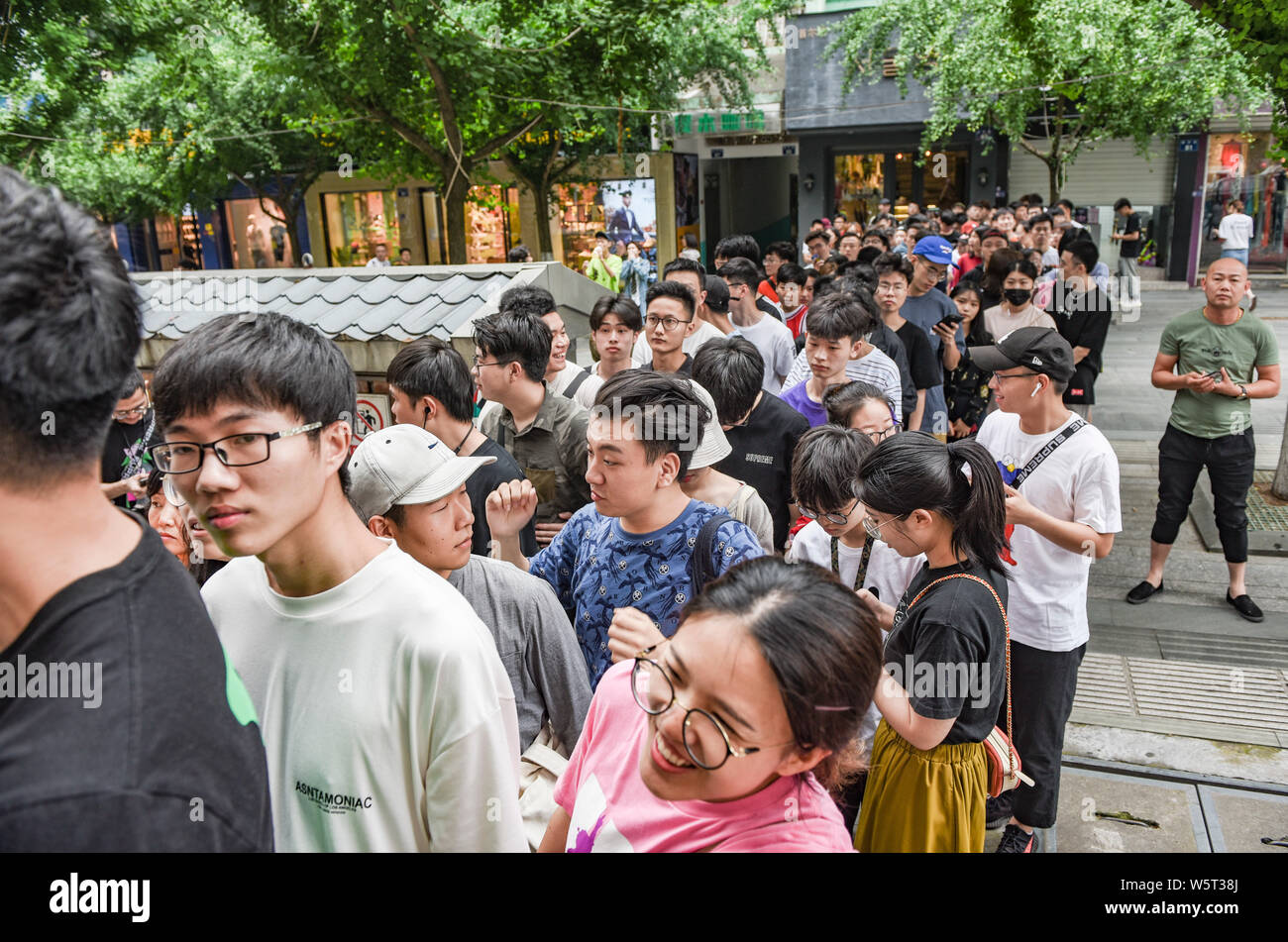 Chinese customers queue up in front of a Uniqlo store to buy the ...