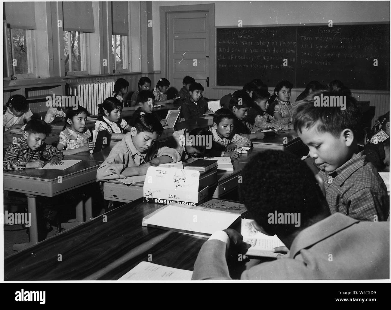 [One student getting assistance from teacher while other students are ...