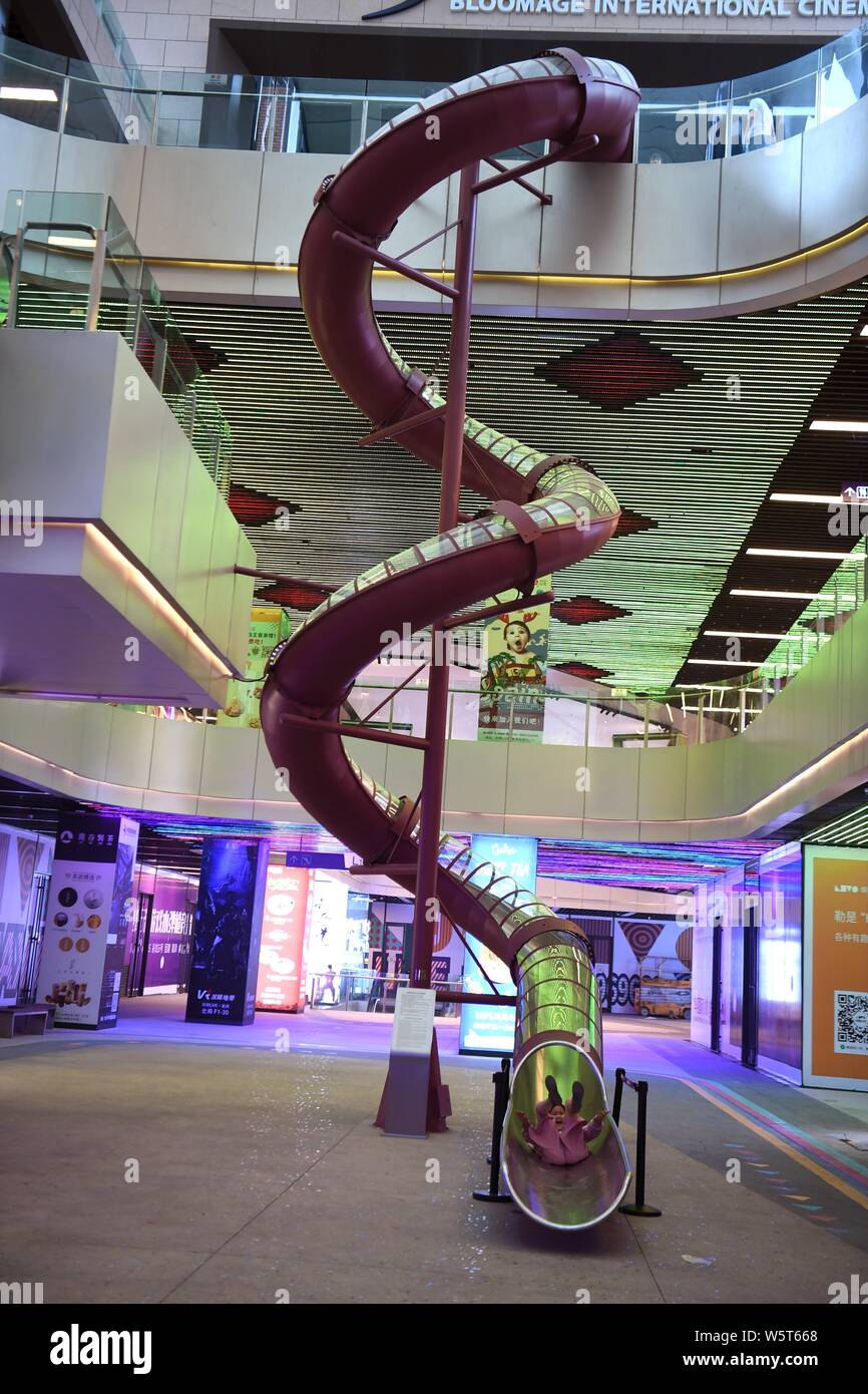 A young Chinese girl tries out the three-storey-high spiral slide at a ...