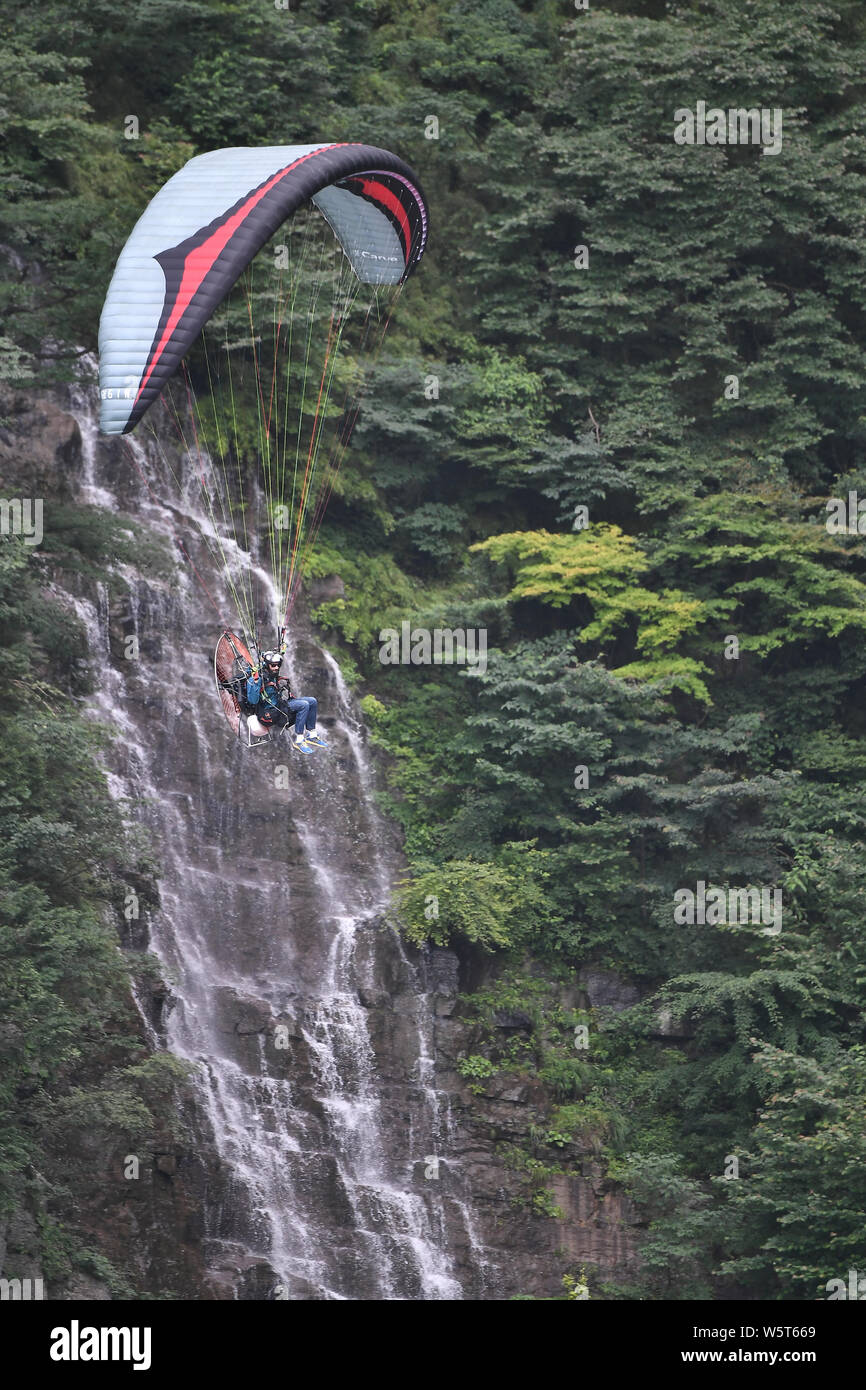 A wingsuit flyer jumps from a high place to glide through the air ...