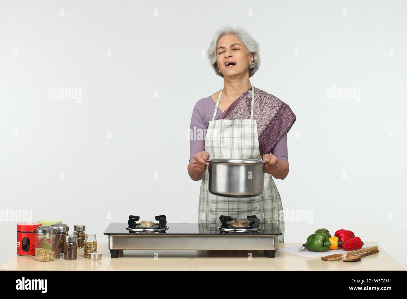 Old woman suffering from pain while cooking food in kitchen Stock Photo ...