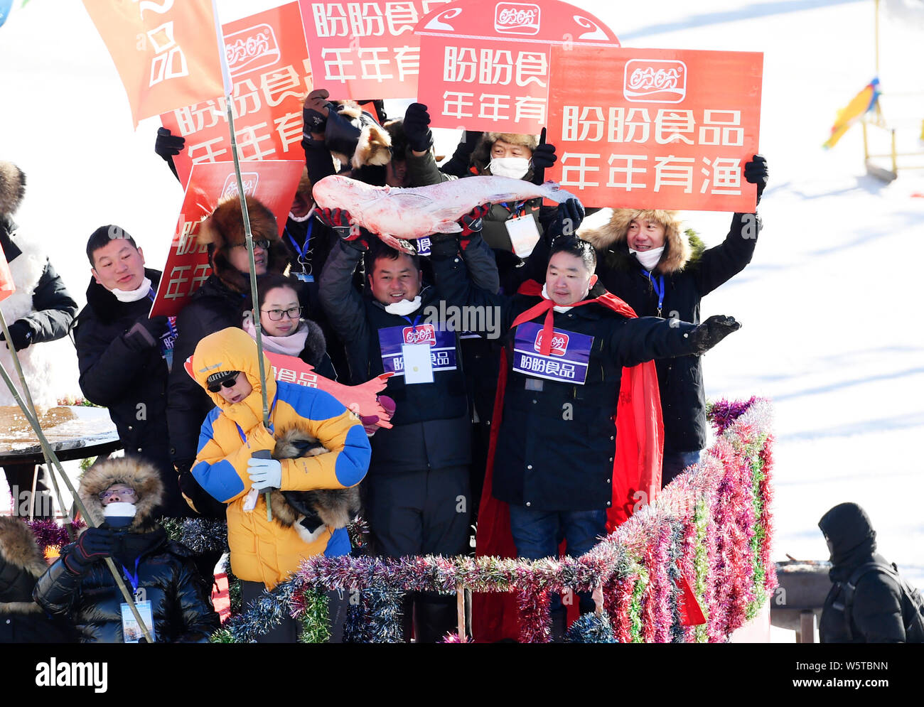 The auction winner shows the first fish harvested from the Chagan Lake ...