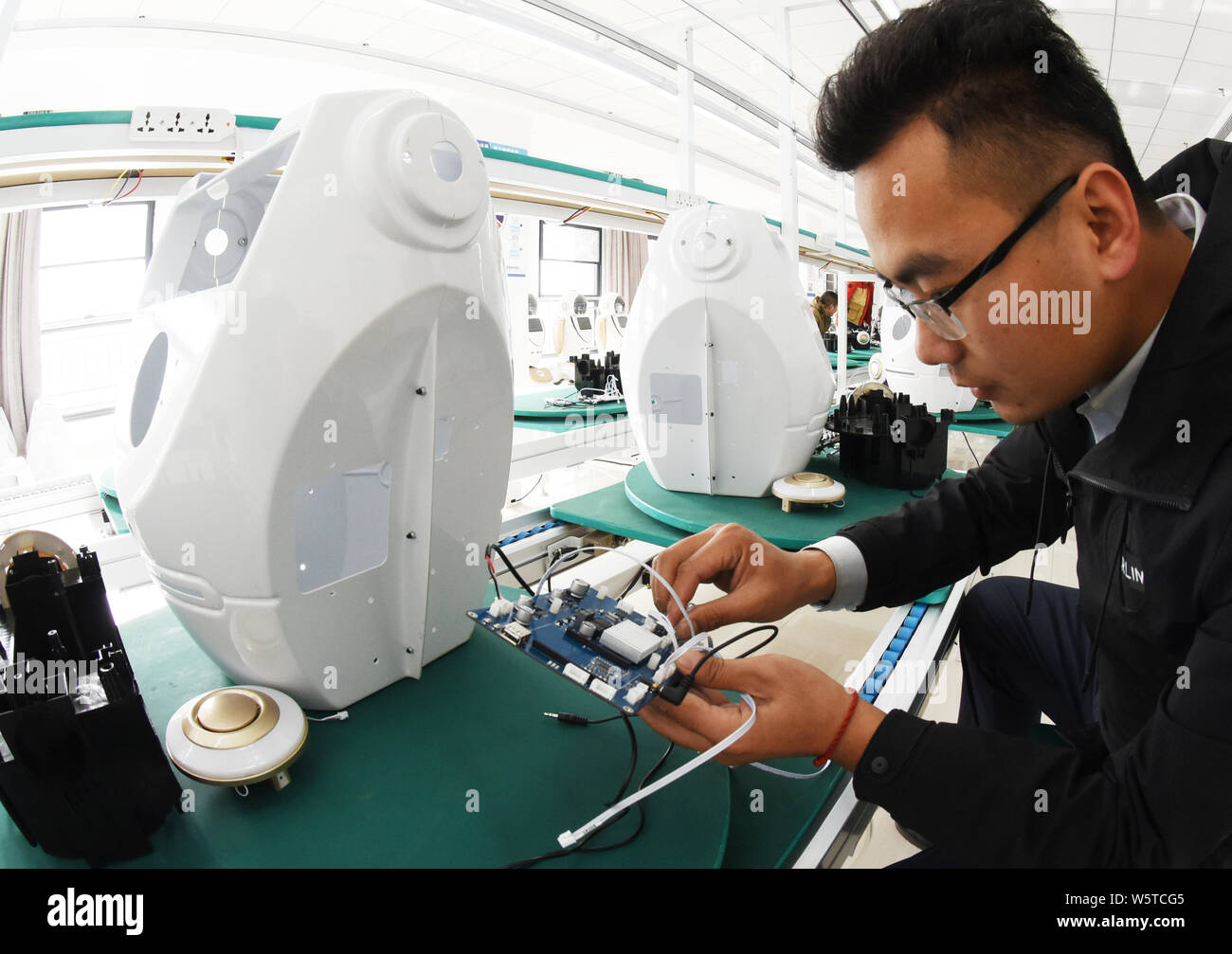 A Chinese worker assembles commercial service robots at the Haizhou ...