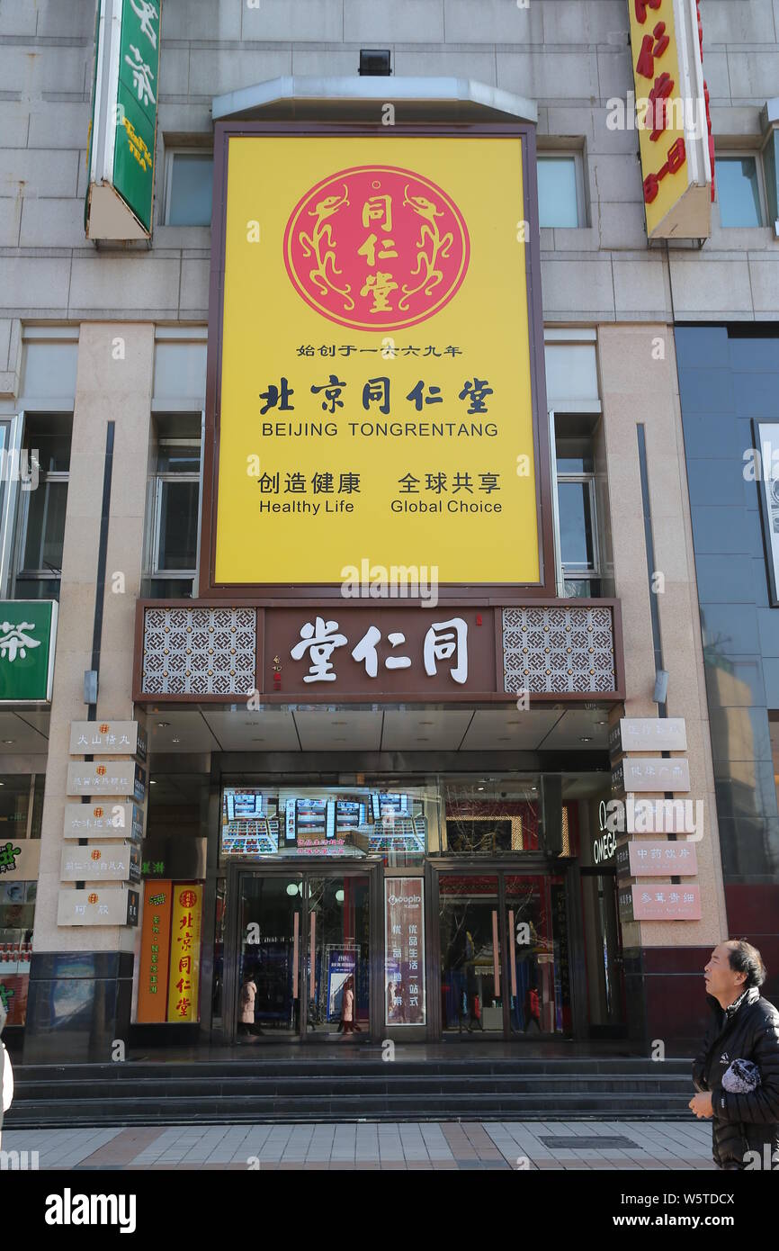 --FILE--Pedestrians walk past a branch of Beijing Tongrentang company ... --FILE--Pedestrians walk past a branch of Beijing Tongrentang company ...