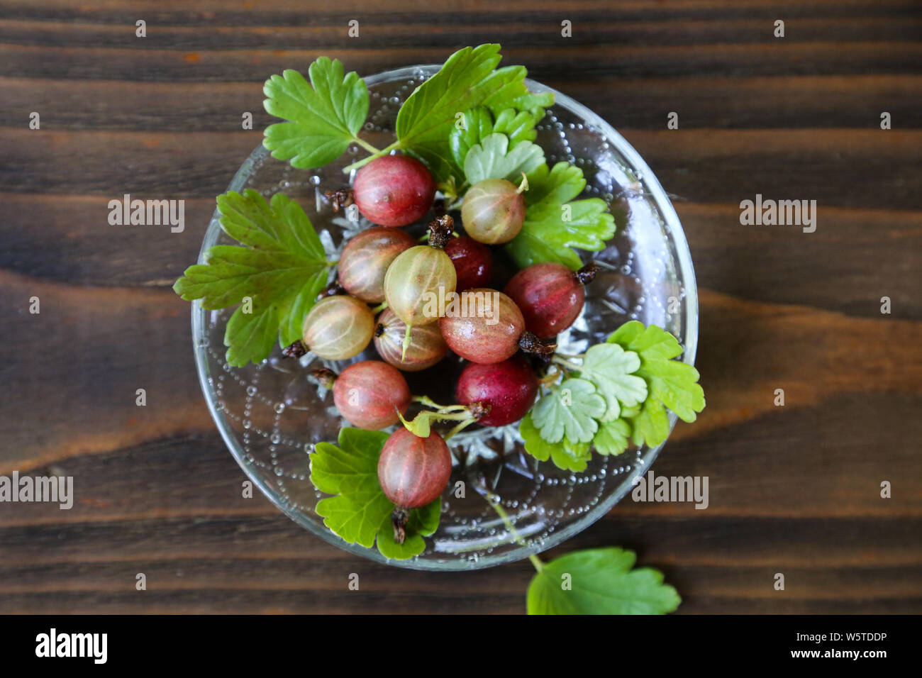 sweet fresh gooseberry berry in a bowl on dark background. top view ...