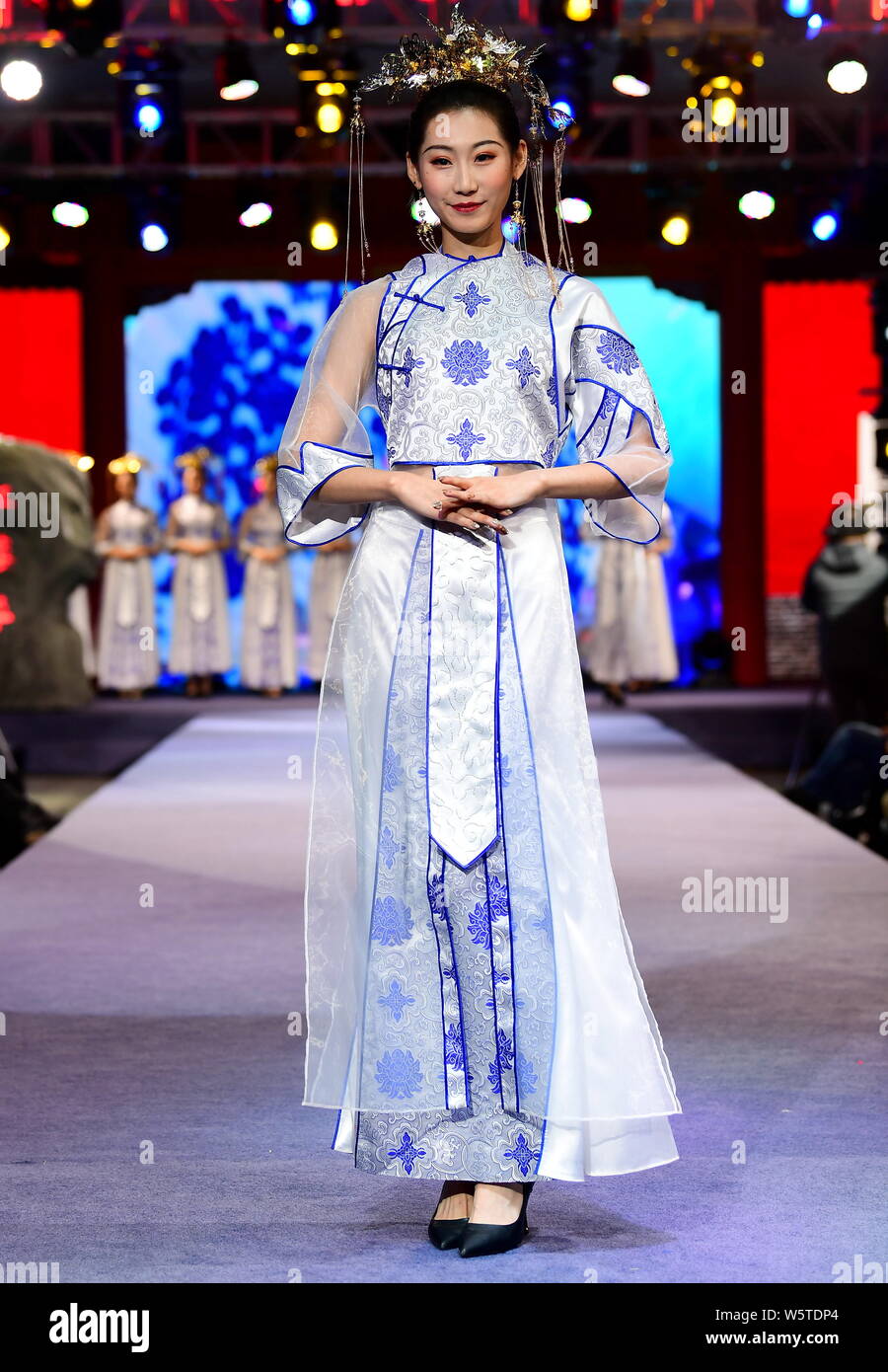 A model presents a new creation of cheongsam (qipao) made of ...
