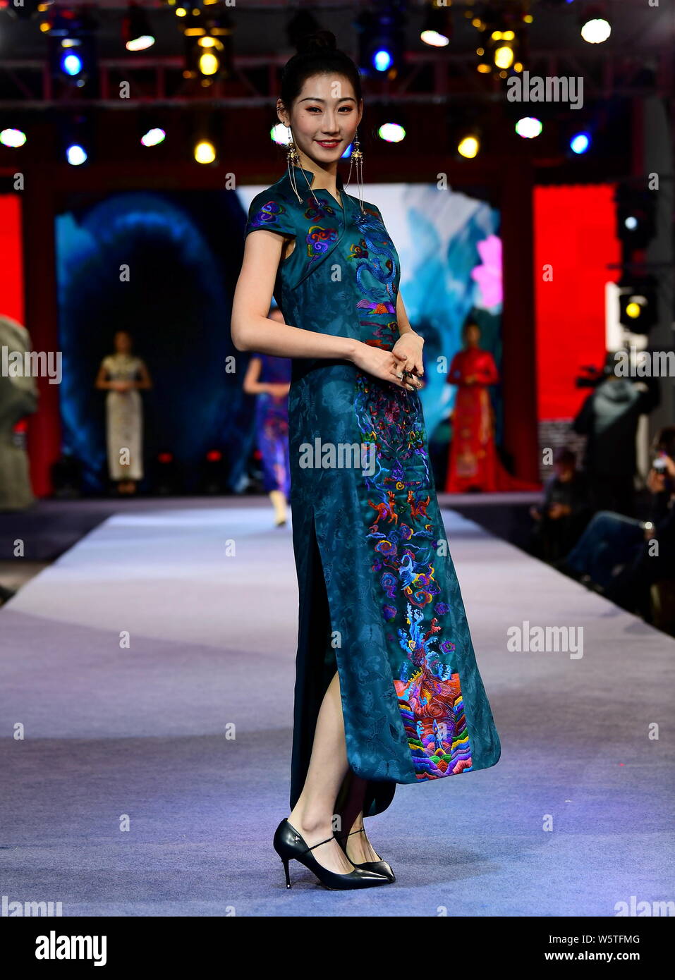 A model presents a new creation of cheongsam (qipao) made of ...