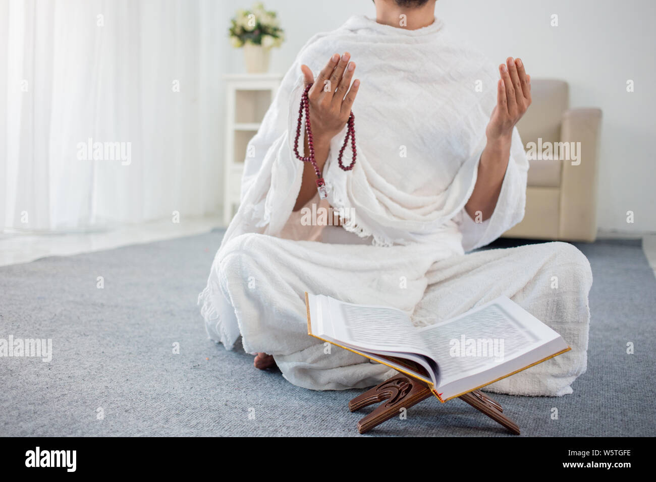 Muslim man praying in white traditional clothes Stock Photo - Alamy