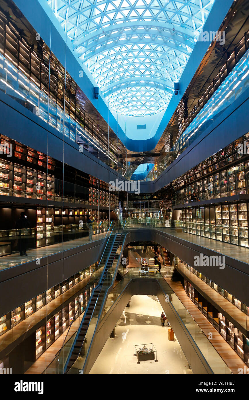 Books are placed on the four-storey-high book wall decorated with glass ...