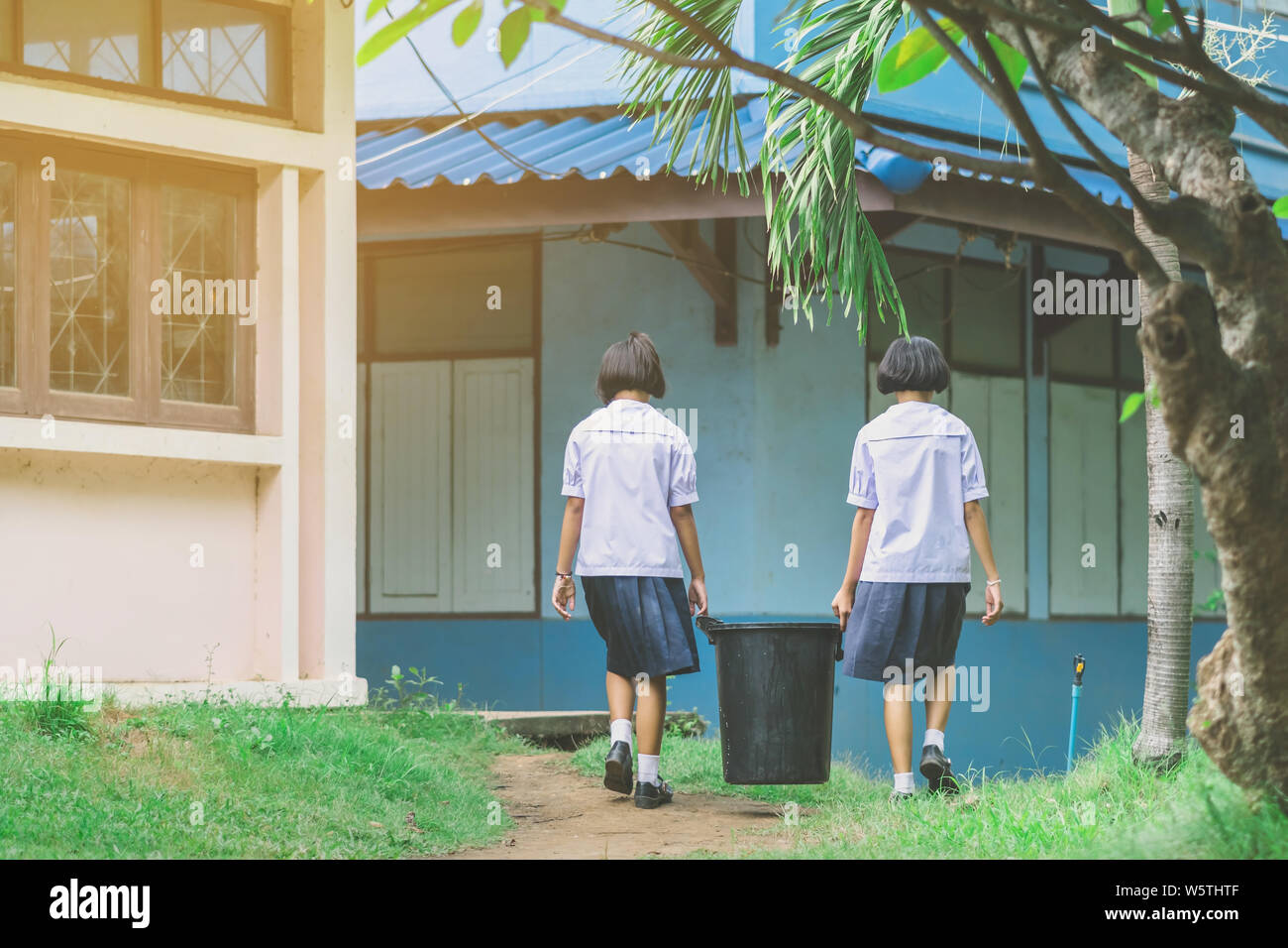 Female Students help to remove rubbish from the classroom to pile waste ...
