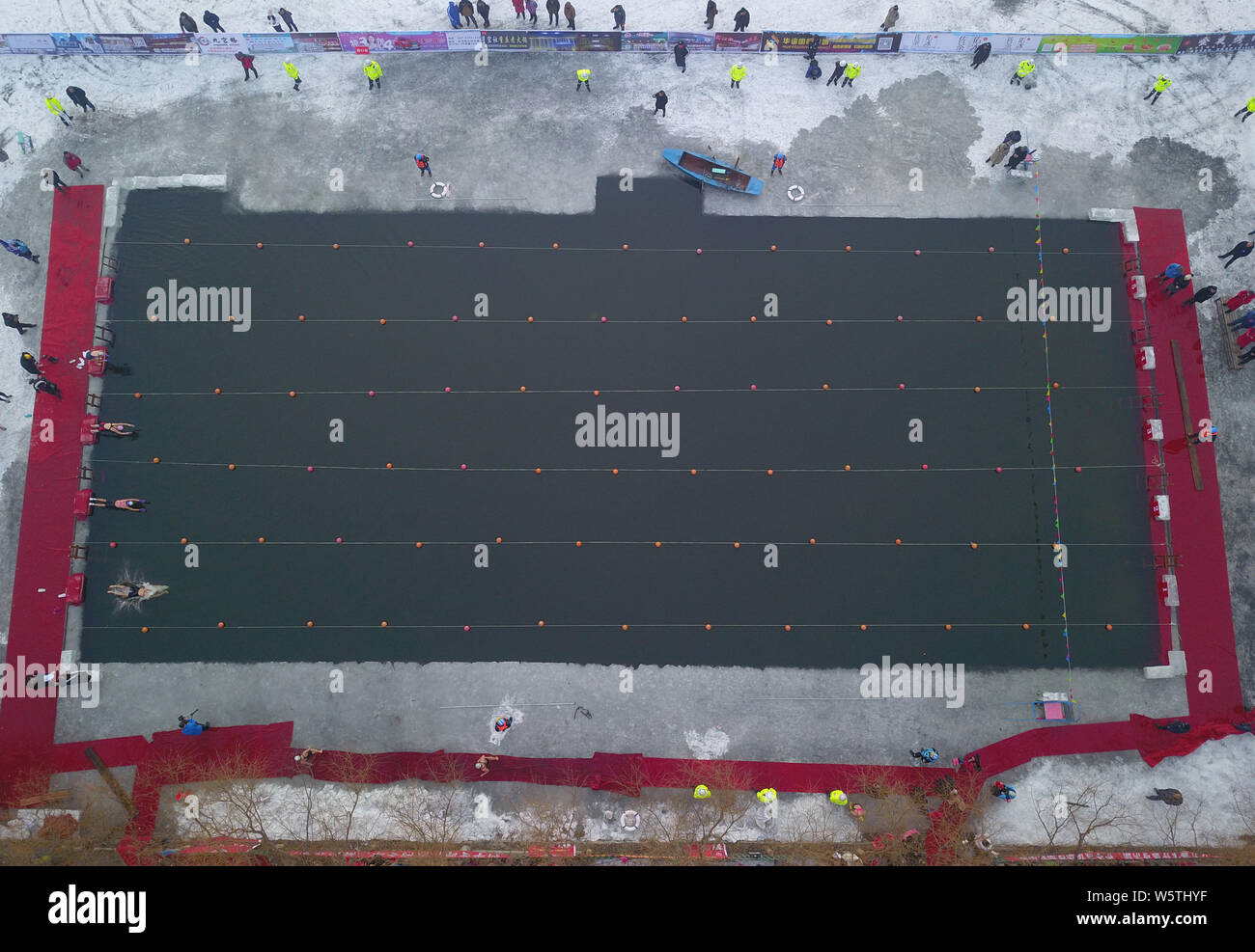 Chinese contestants jump into the freezing water during a winter ...