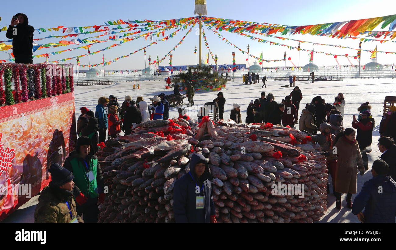Tourists look at a 10-meter-long "fish wall" composed of more than ...