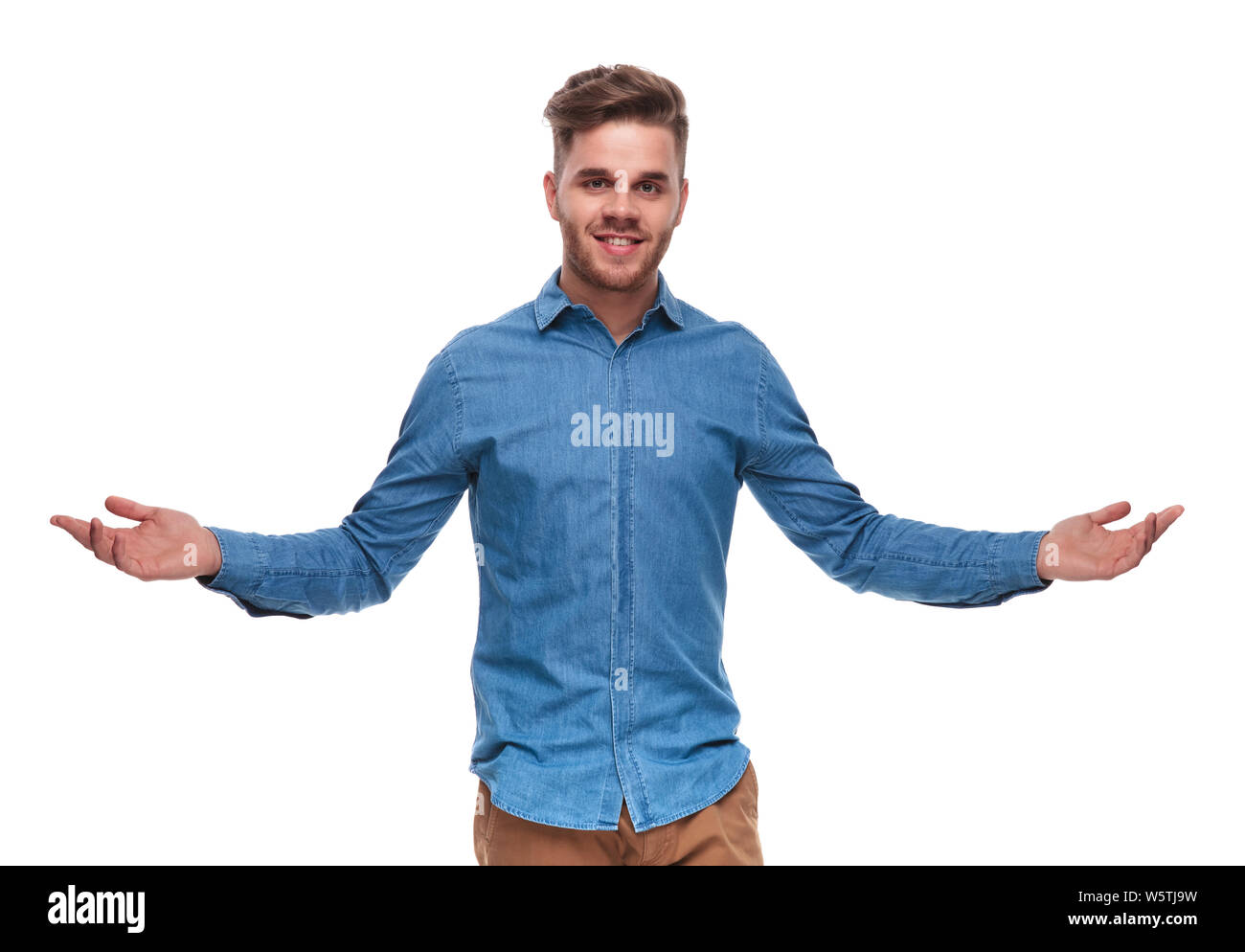portrait of casual young man making an open hands gesture while ...