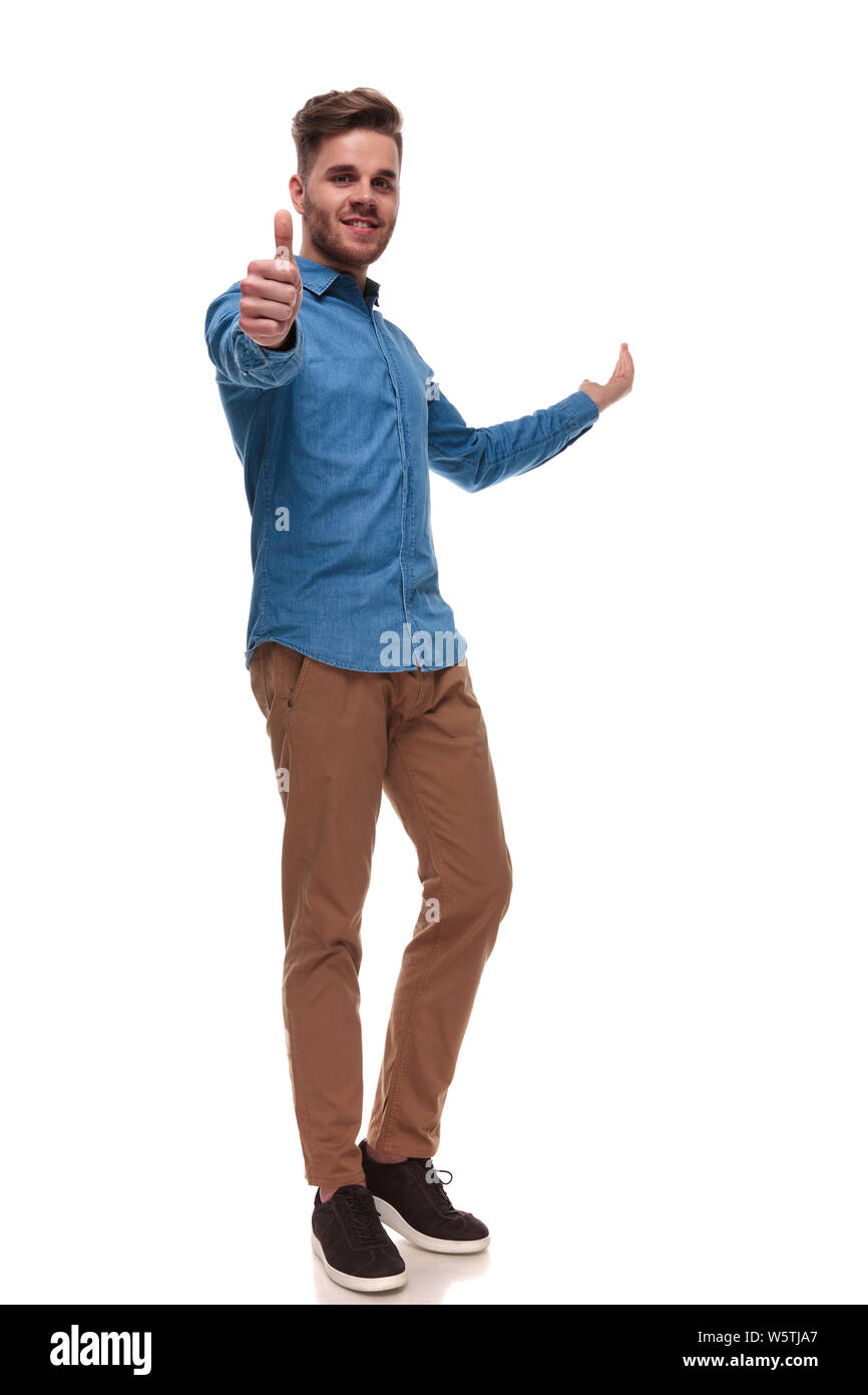 handsome casual man makes ok sign and presents behind while standing on ...