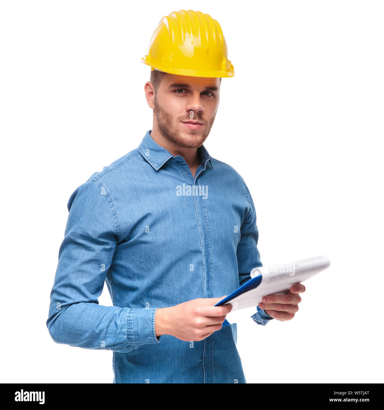 portrait of handsome engineer with clipboard in hand and safety helmet ...