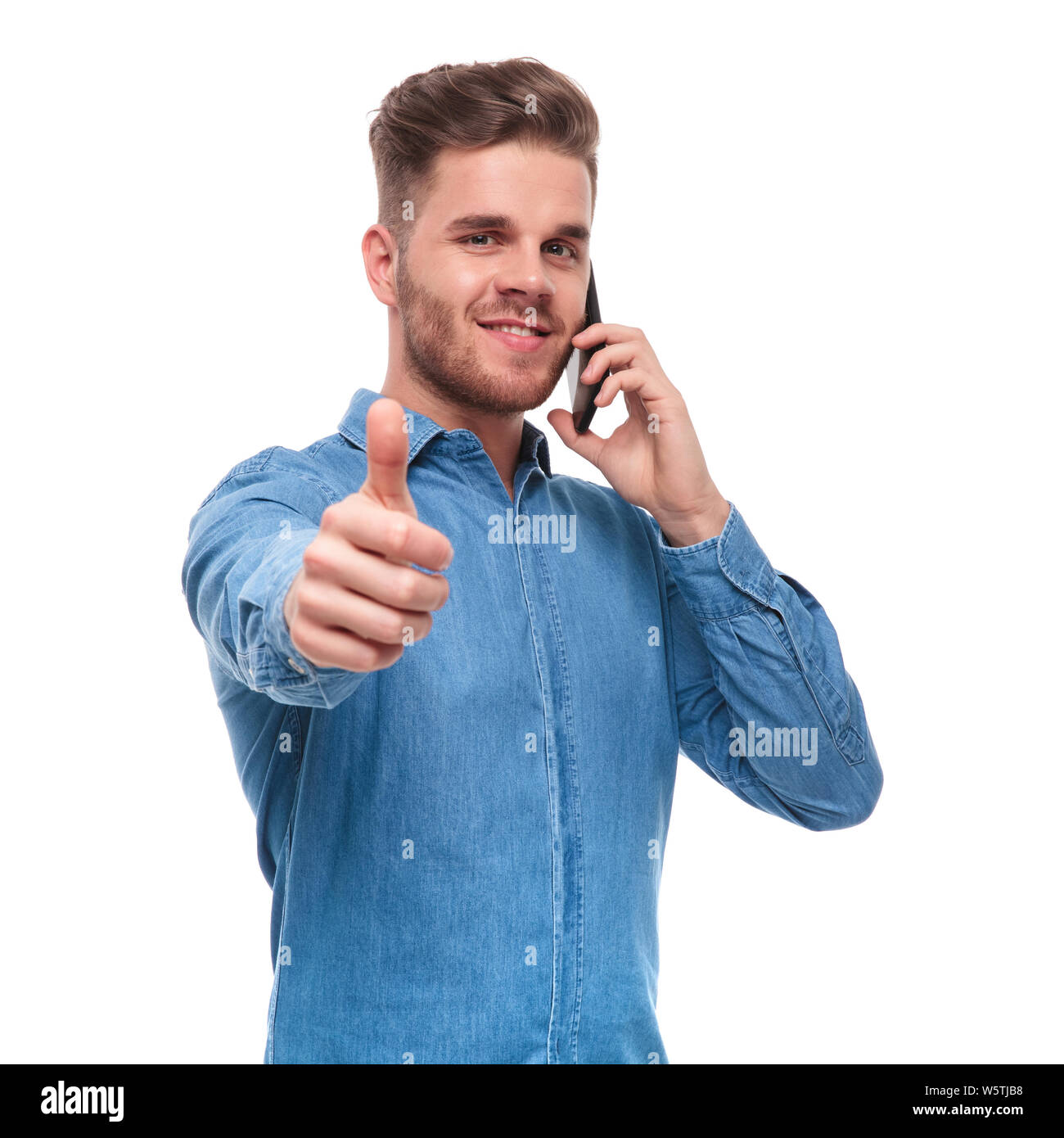 attractive casual man speaking on the phone makes ok sign while ...