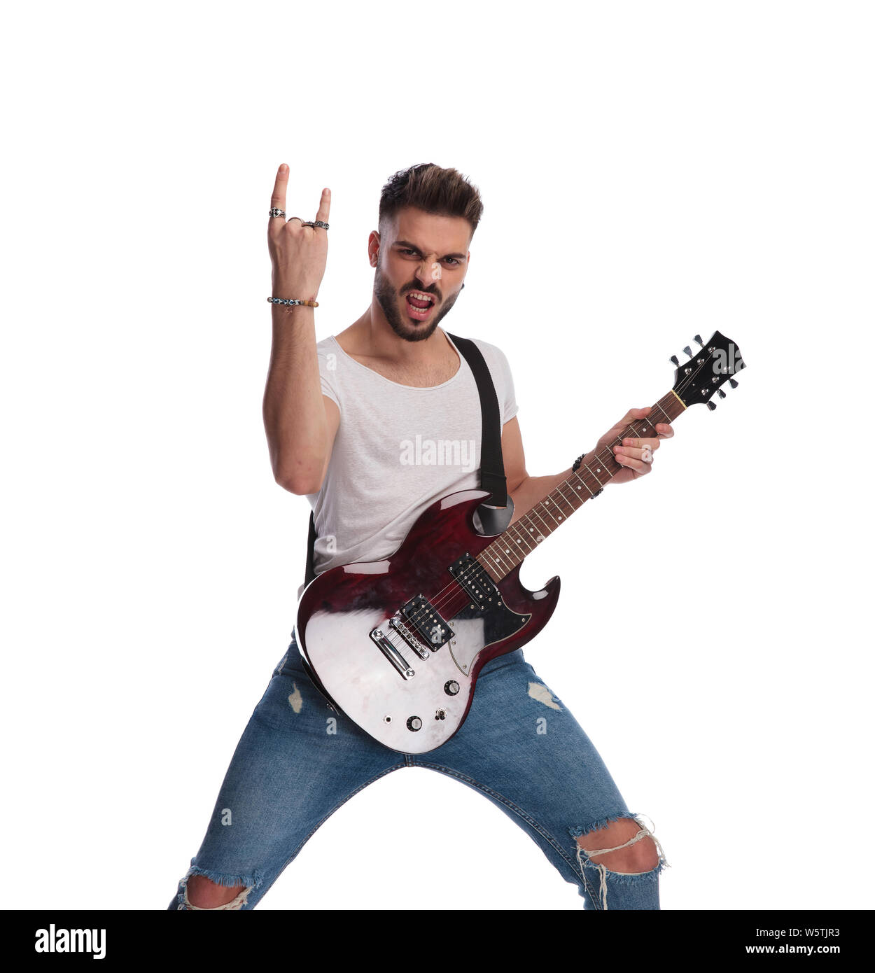 male guitarist performing on white background and making rock on sign ...