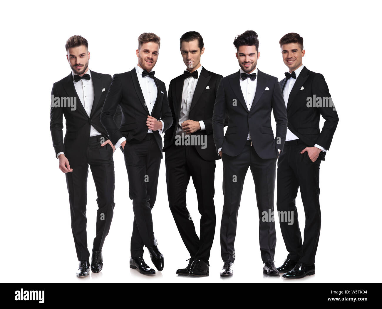 five handsome men in black tuxedoes standing together on white ...