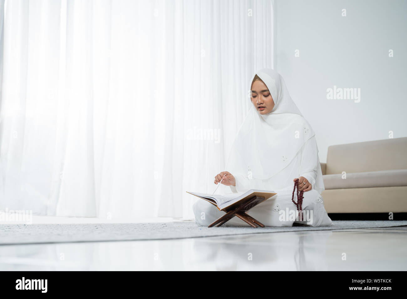 Muslim young woman praying in white traditional clothes Stock Photo - Alamy