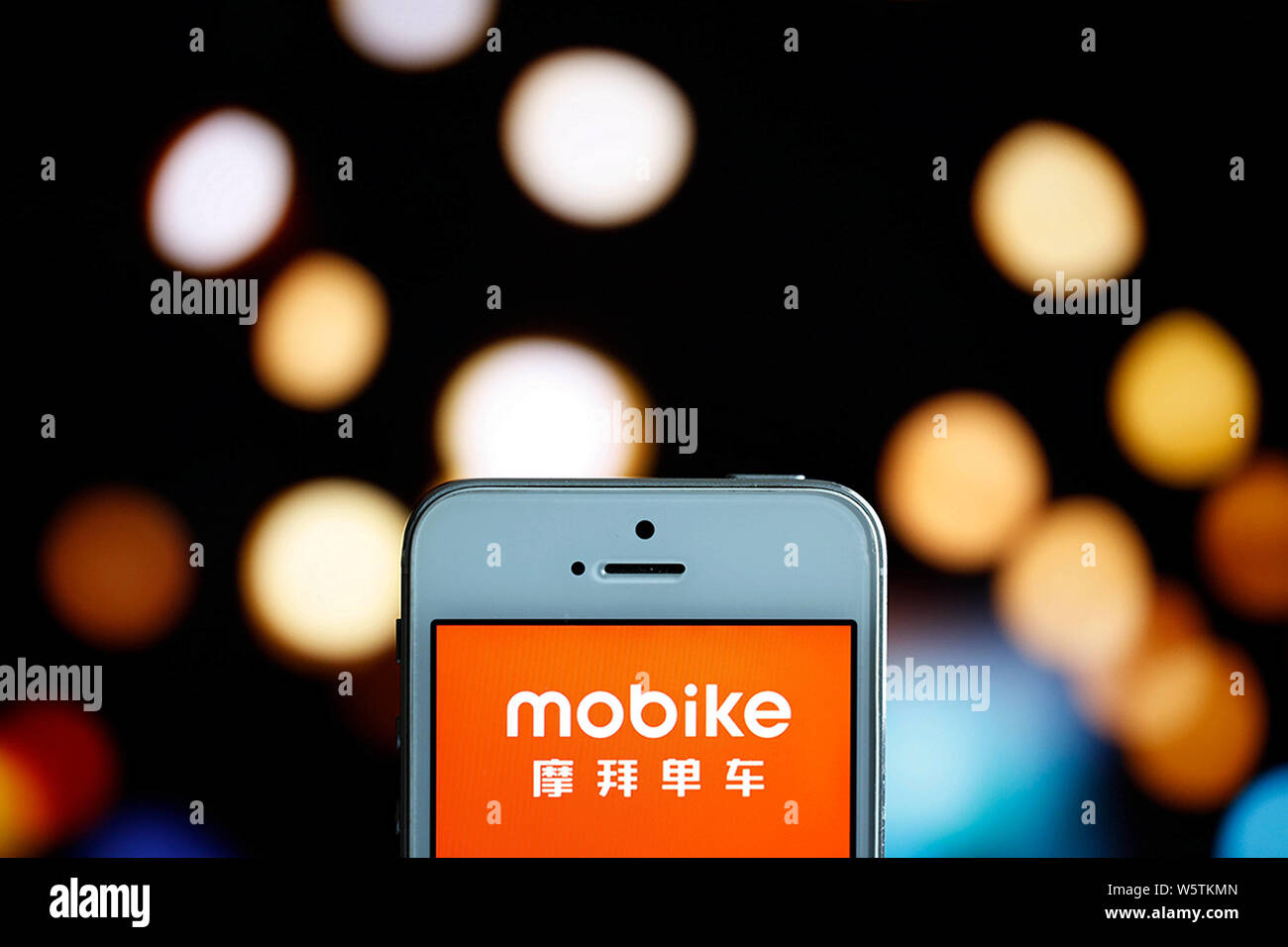 A netizen browses a logo of Chinese bike-sharing service Mobike on his smartphone in Beijing ...