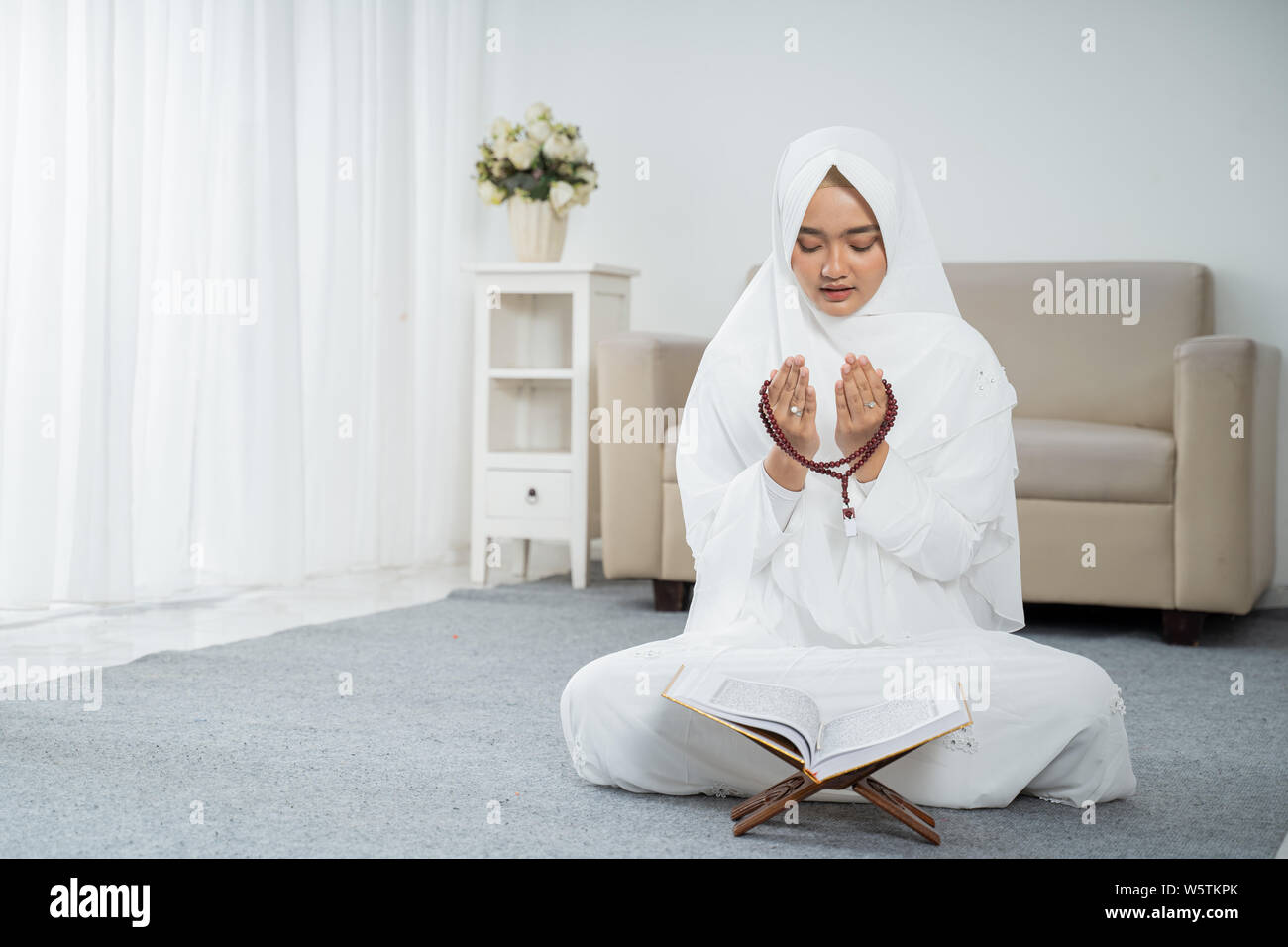 Muslim young woman praying in white traditional clothes Stock Photo - Alamy