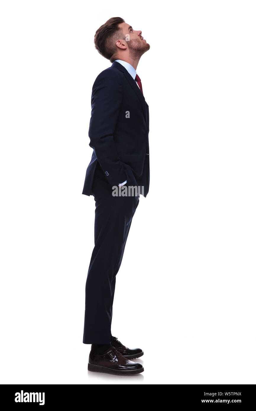 side view of relaxed standing businessman looking up at something on ...