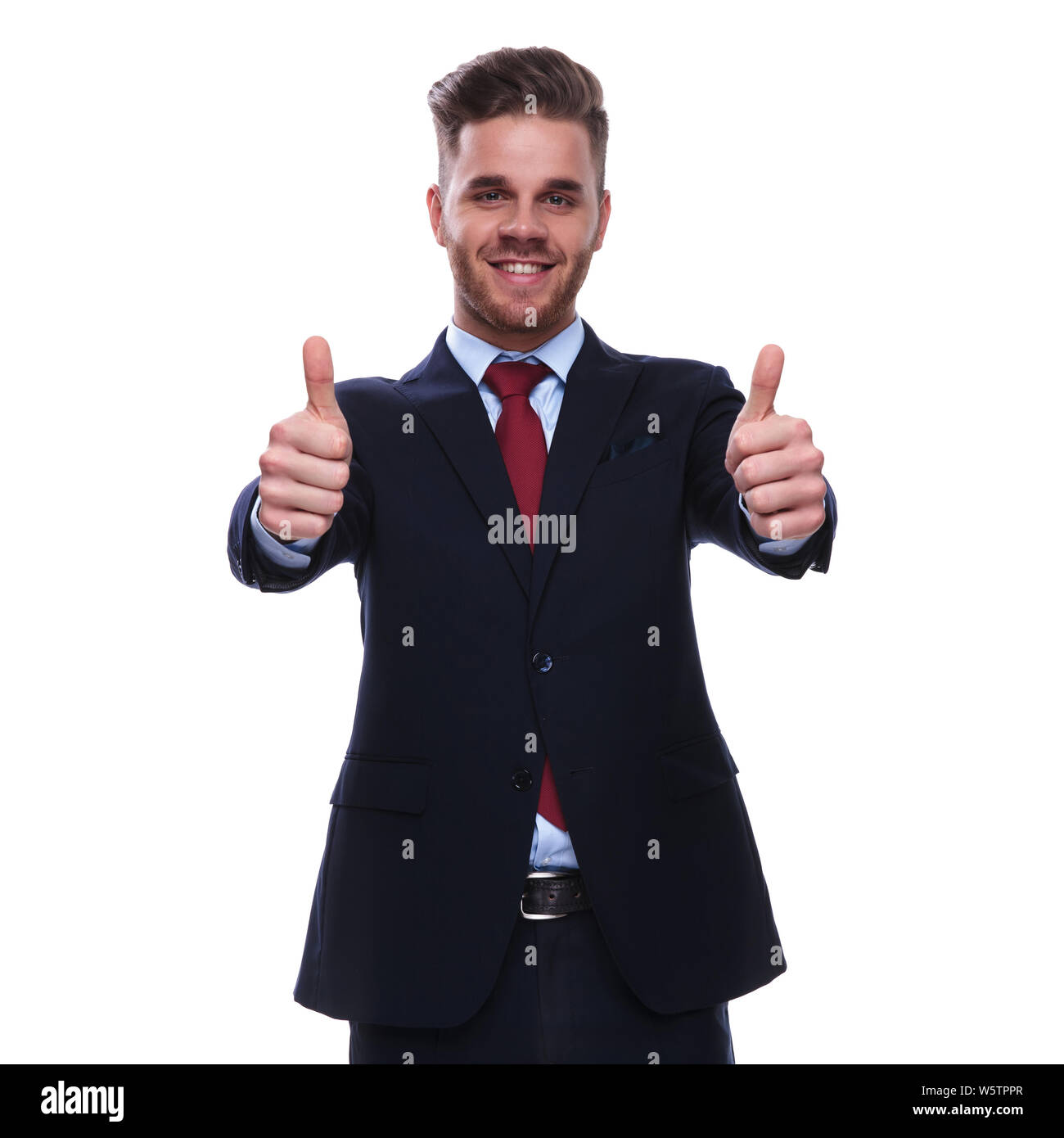 portrait of smiling businessman in navy suit making thumbs up sign ...