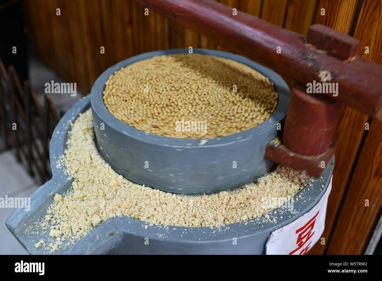 A robot featuring the shape of a village woman makes tofu with a ...