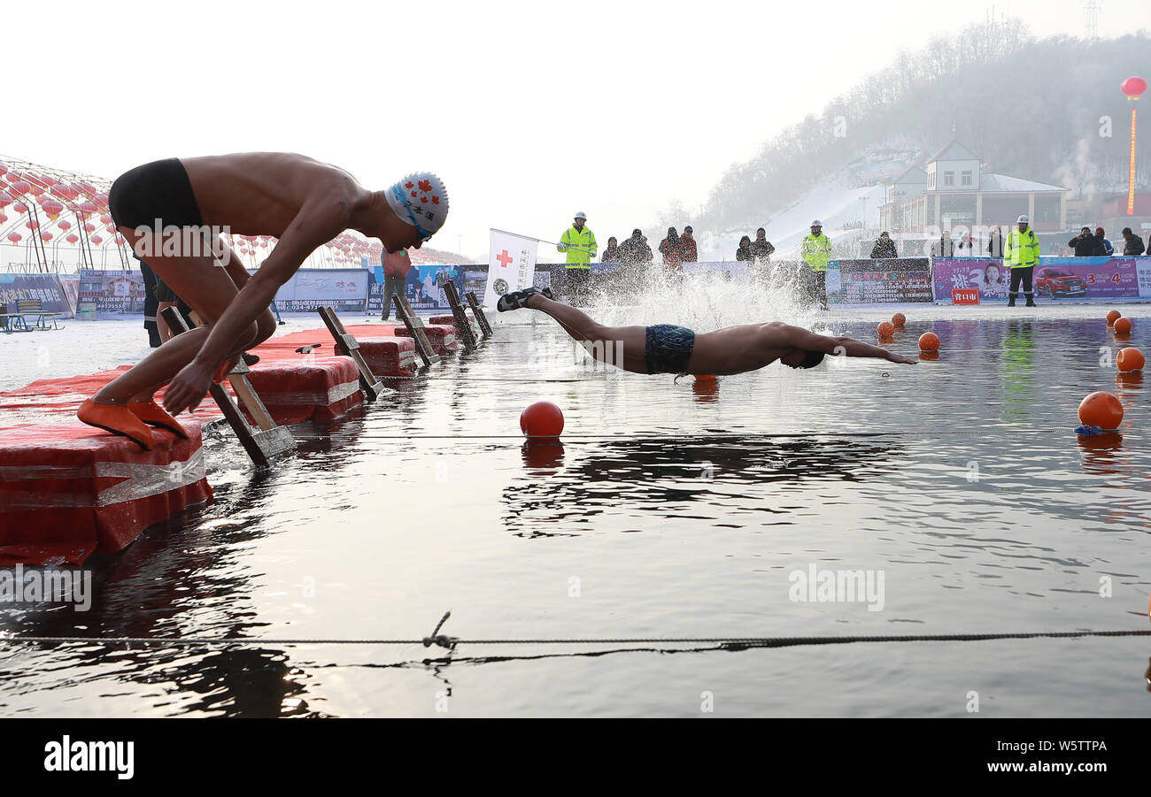 Chinese contestants jump into the freezing water during a winter ...