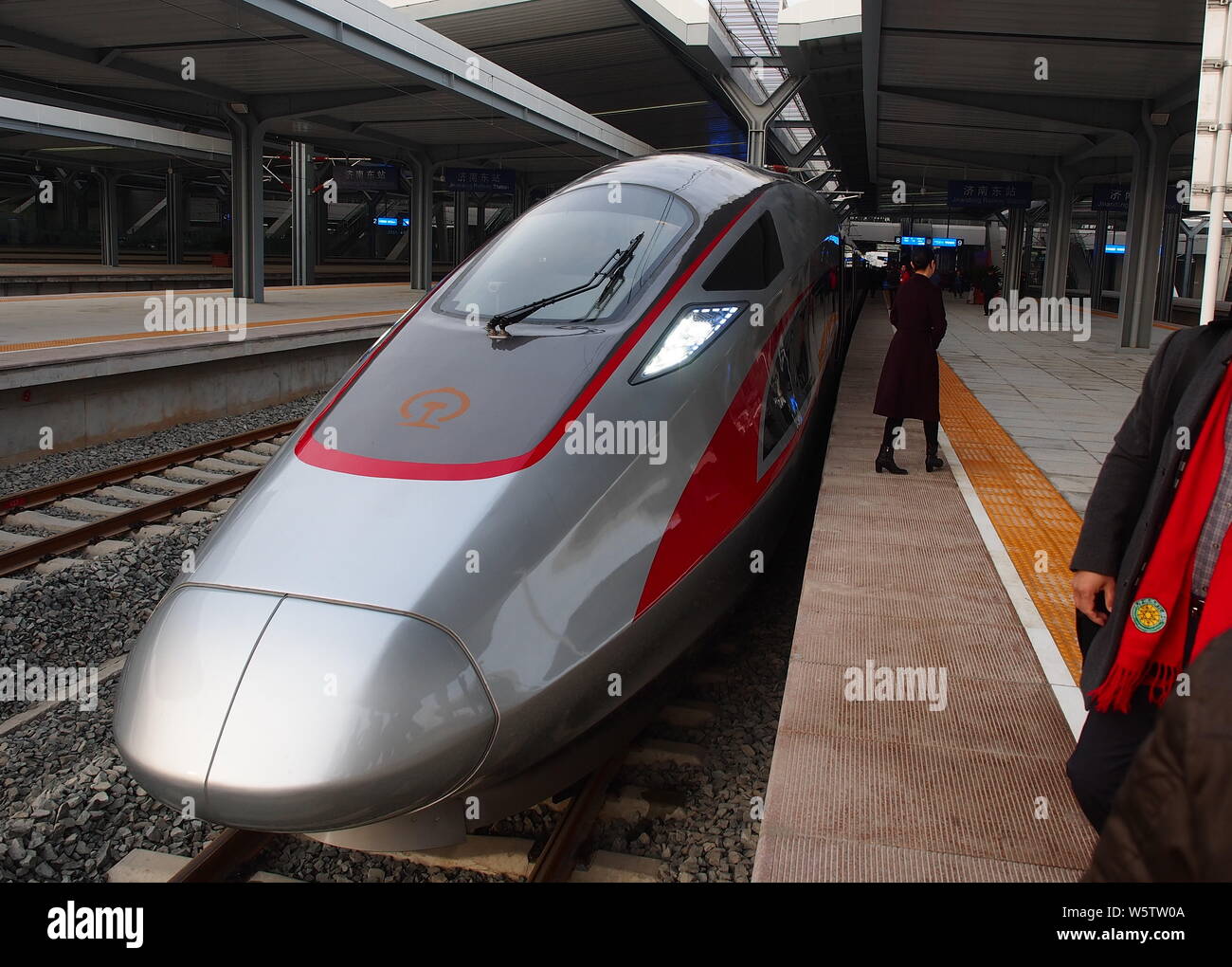 Passengers board a Fuxing high-speed bullet train running on the Jinan ...
