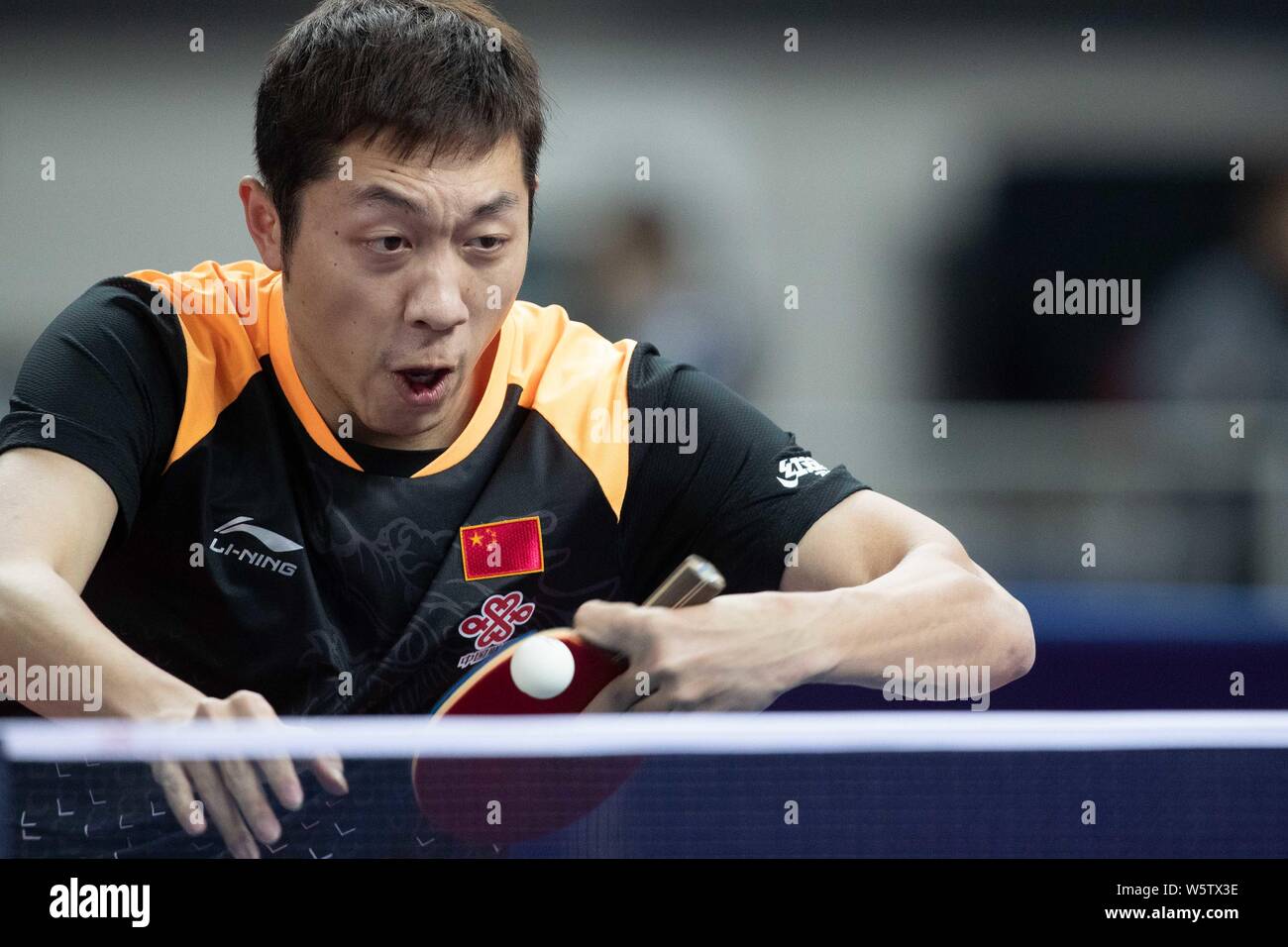 Xu Xin of China returns a shot to Wong Chun Ting of Hong Kong in their ...