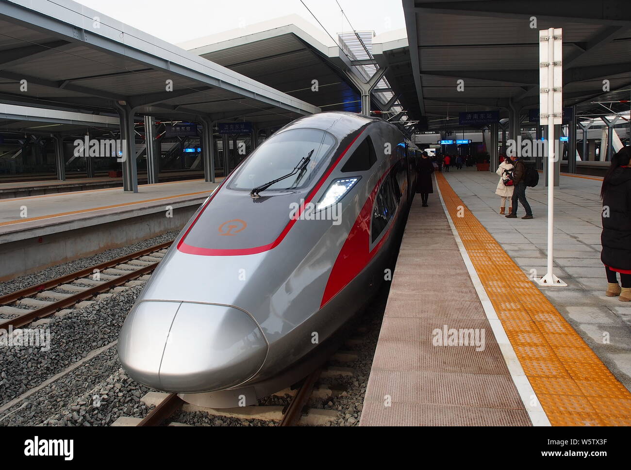 Passengers board a Fuxing high-speed bullet train running on the Jinan ...