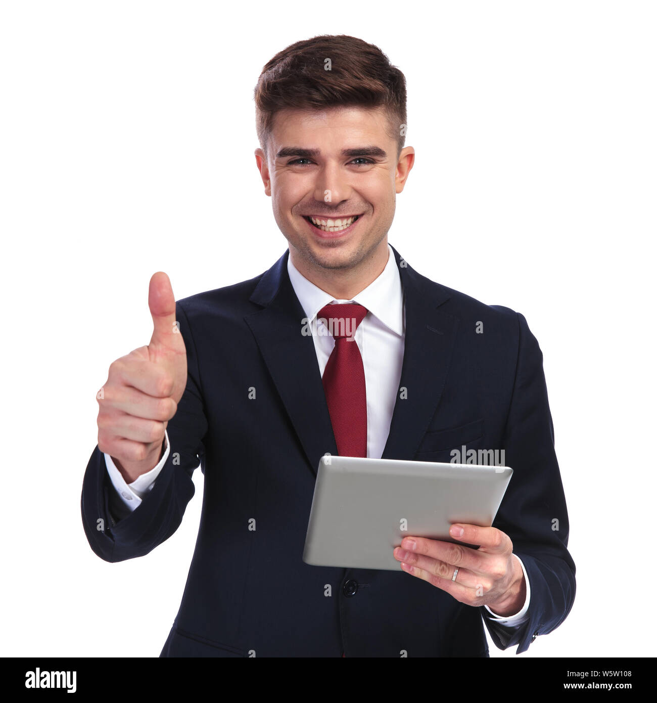 portrait of smiling businessman holding tablet and making ok sign while ...